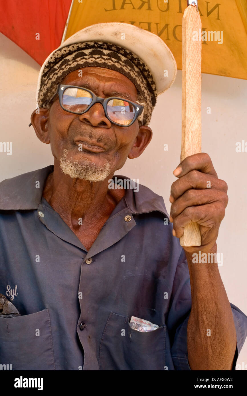 Man holding a colourful parasol to shelter from the sun in Stone Town ...