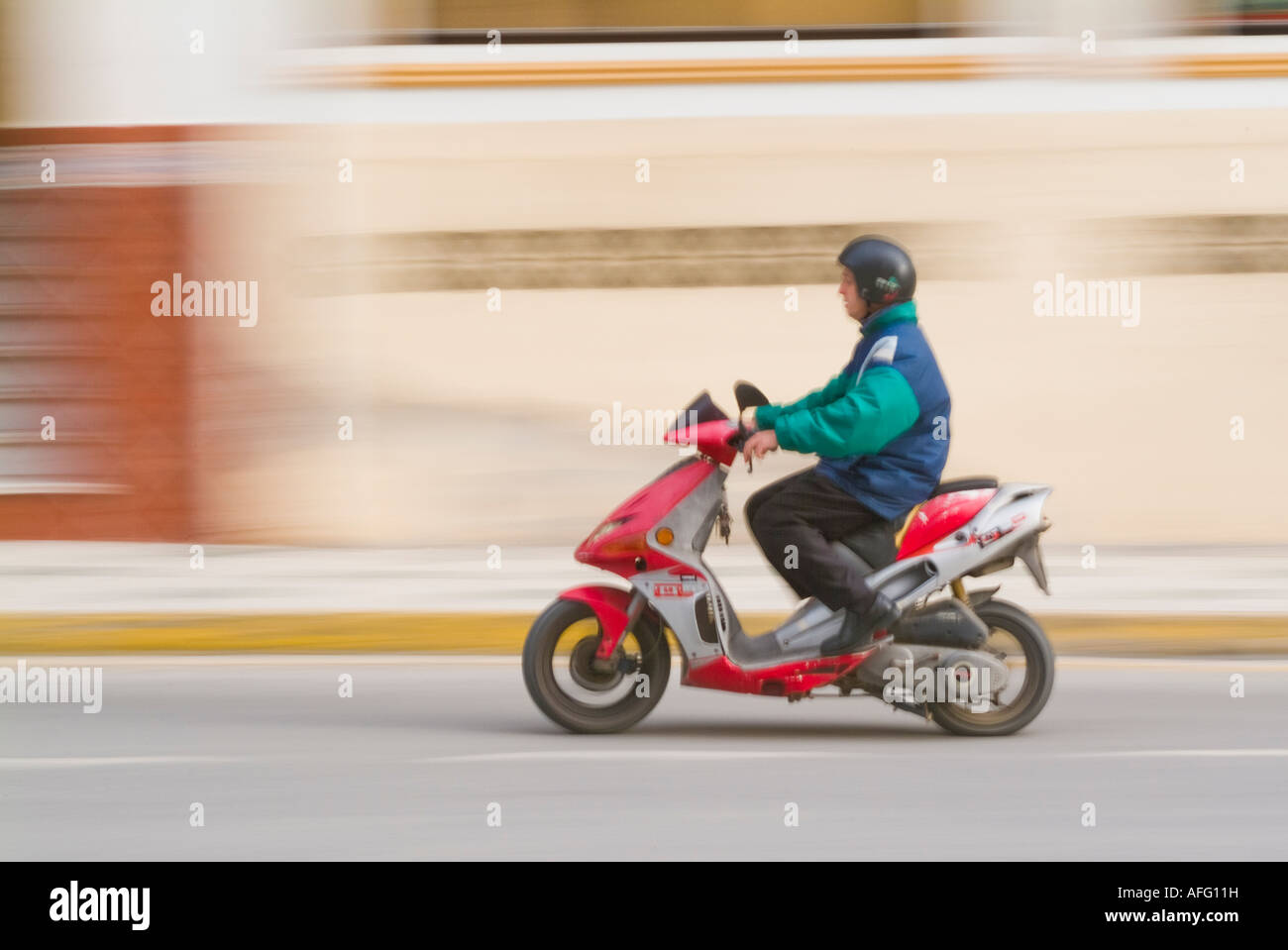 Mopeds with riders on city street in Nerja Spain Stock Photo - Alamy