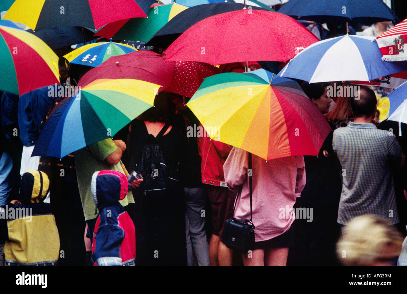 crowd of people sheltering for the rain under umbrellas Stock Photo - Alamy