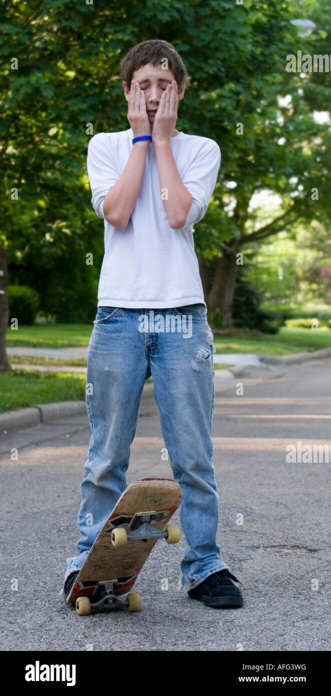 Tired boy with skateboard Stock Photo - Alamy