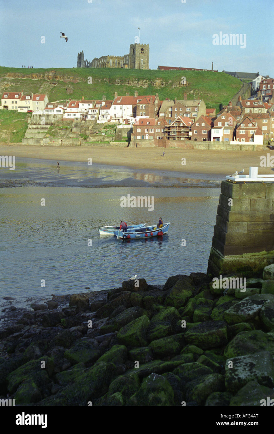 Fishermen in Whitby Harbour with St Marys Church and the Abbey Stock ...