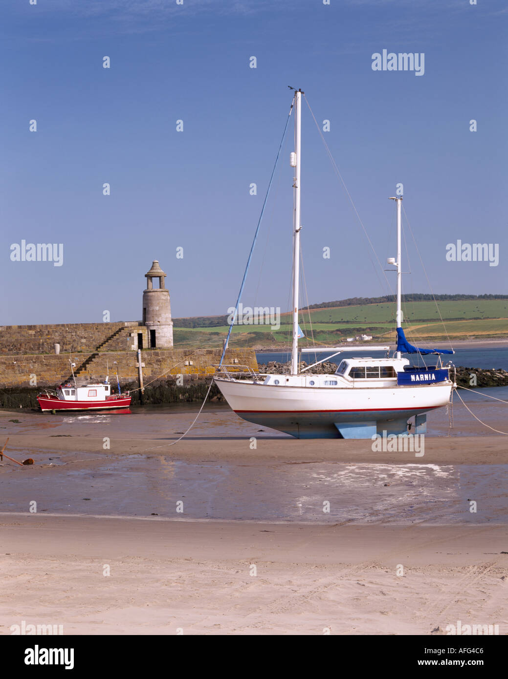 Port Logan in the Rhins of Galloway looking across beach to yacht and ...