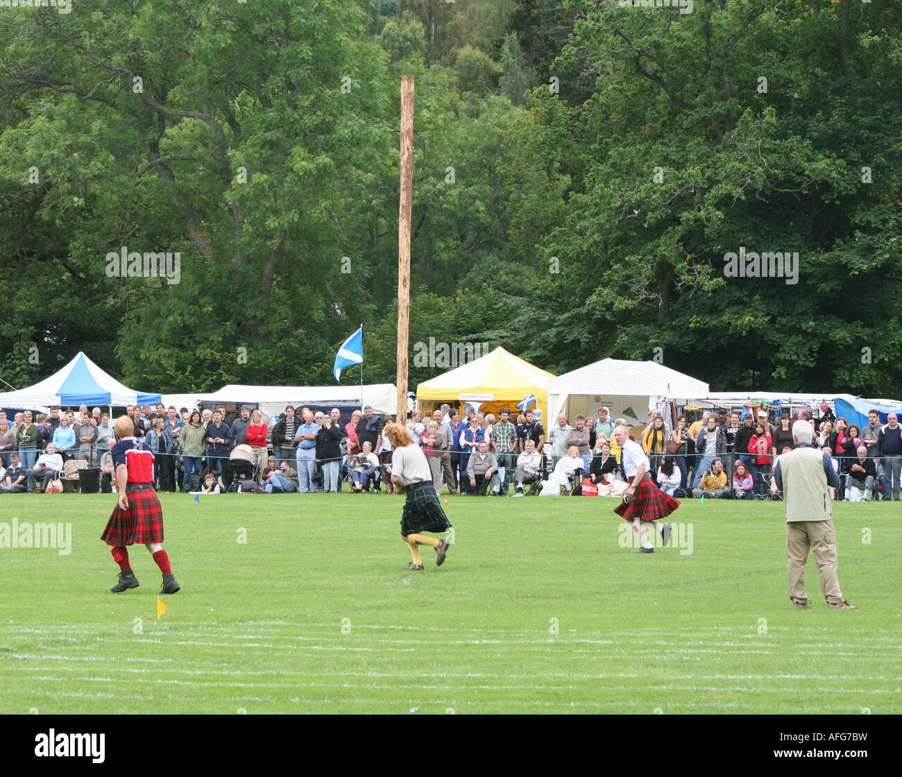 Scottish man in kilt running with caber at Pitlochry highland games ...