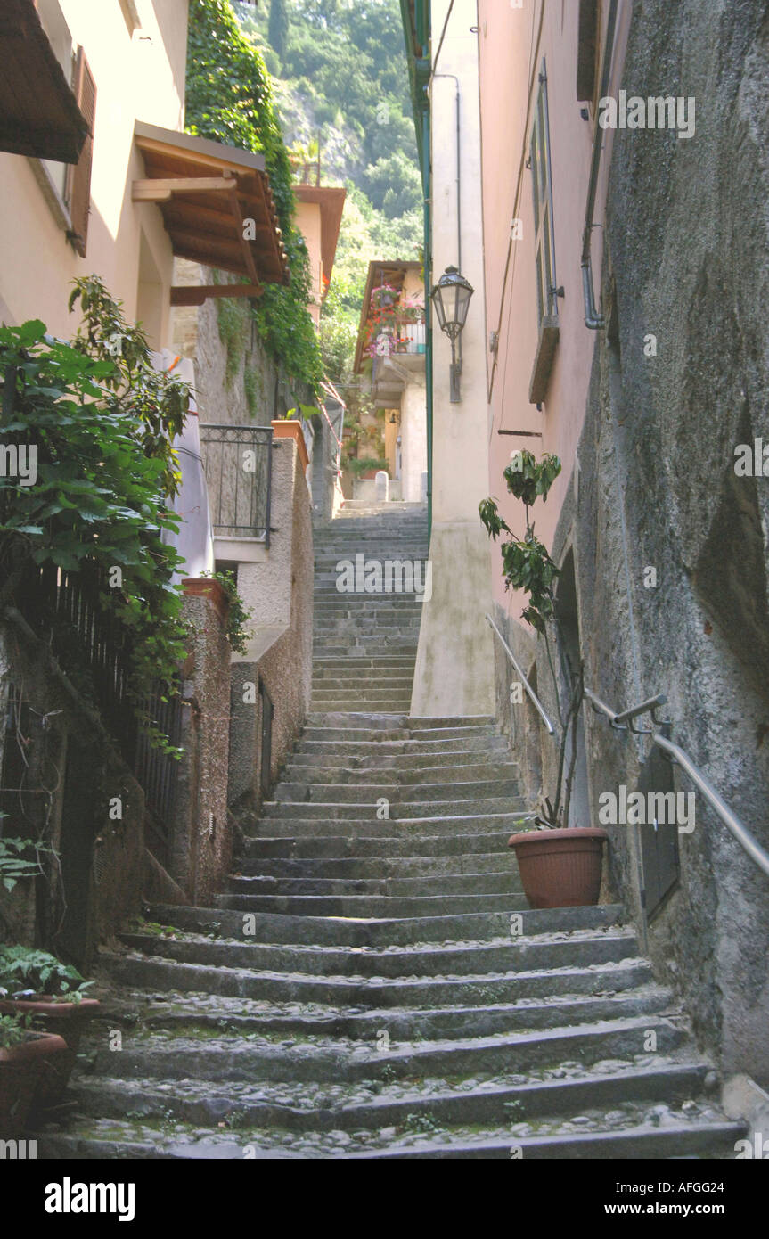 Narrow pedestrian walkway leading uphill from Lake Como in village of ...