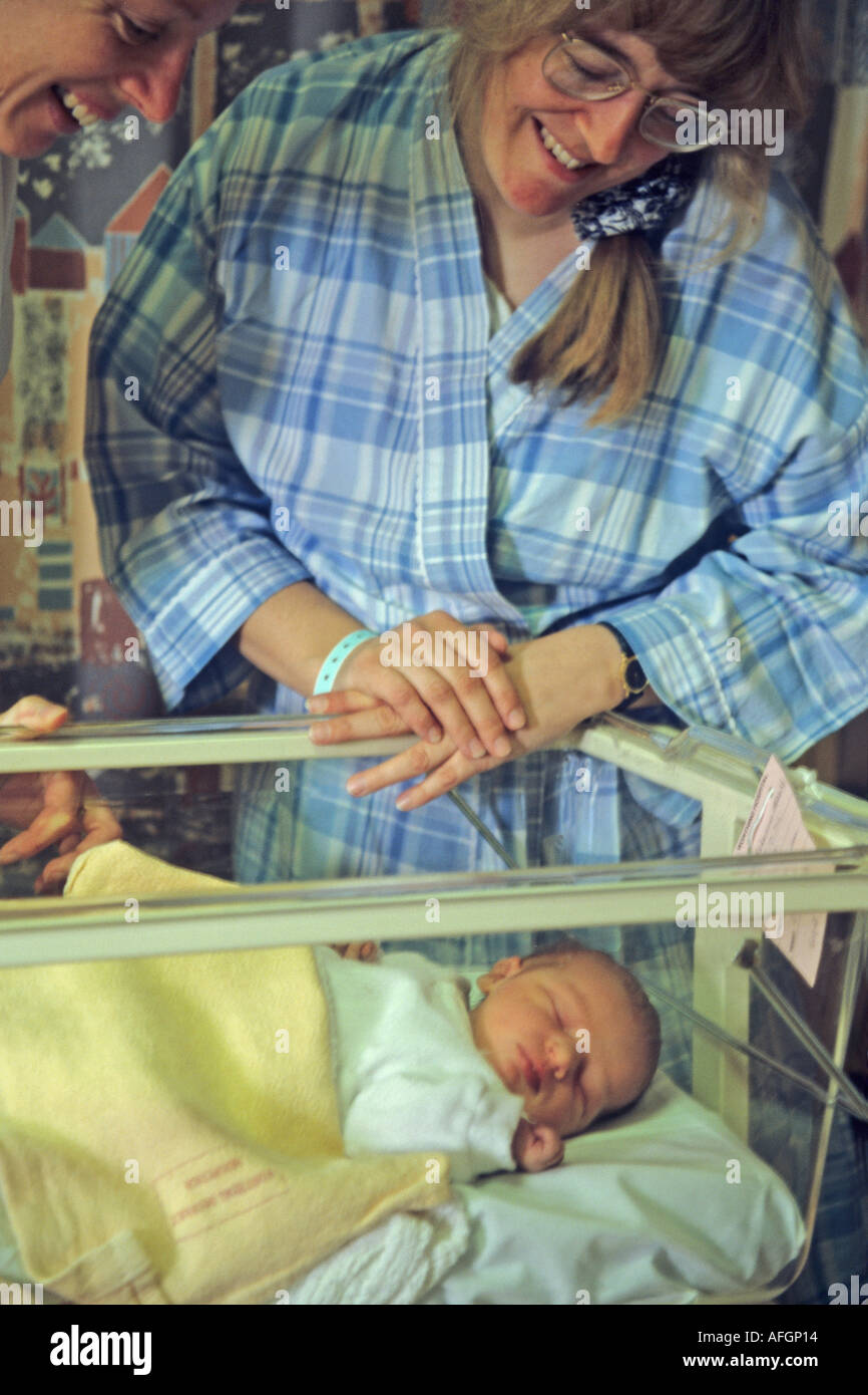 midwife and young mother with new born baby in hospital maternity ward ...