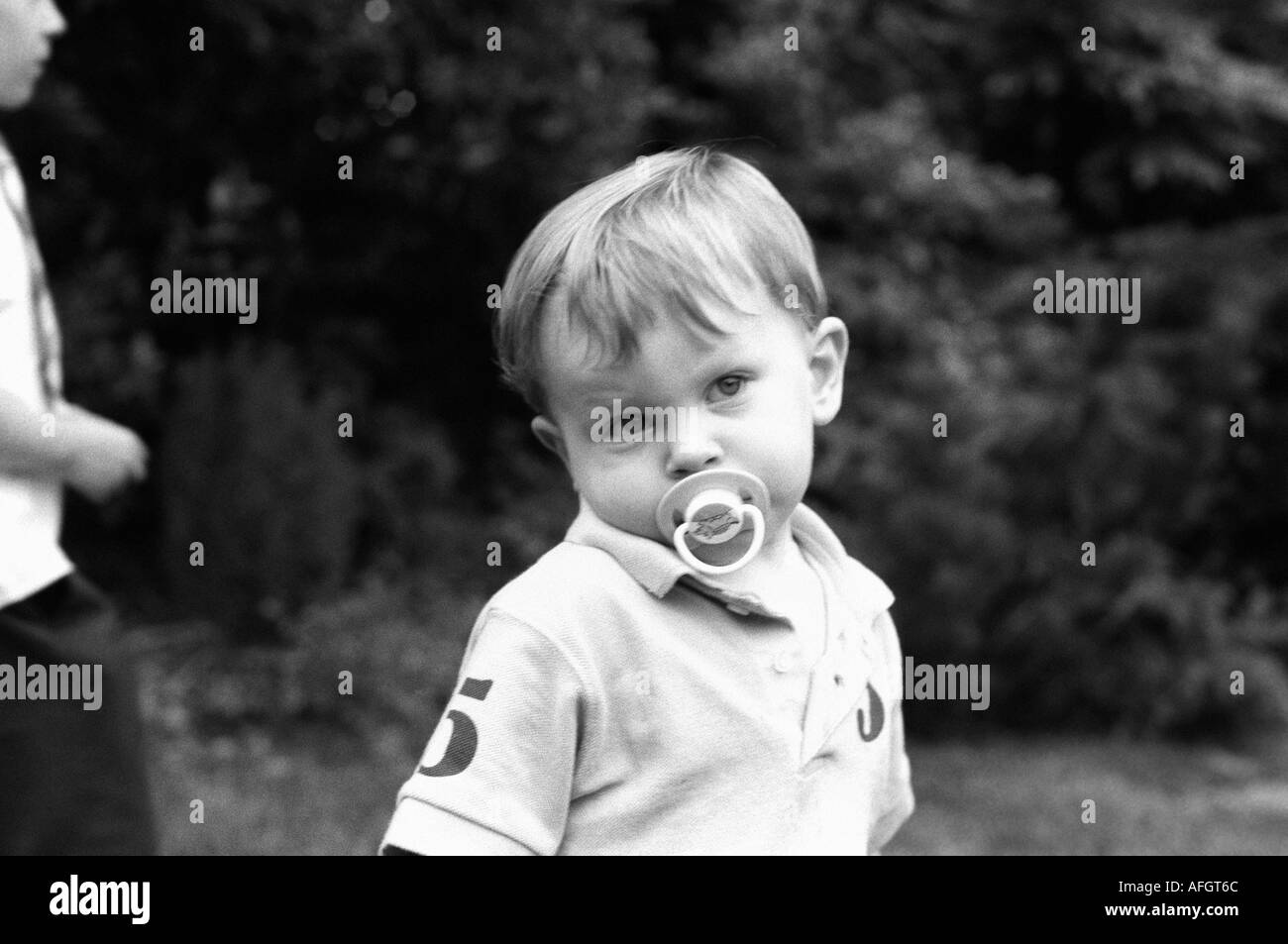 A young boy with a dummy in his mouth Stock Photo - Alamy