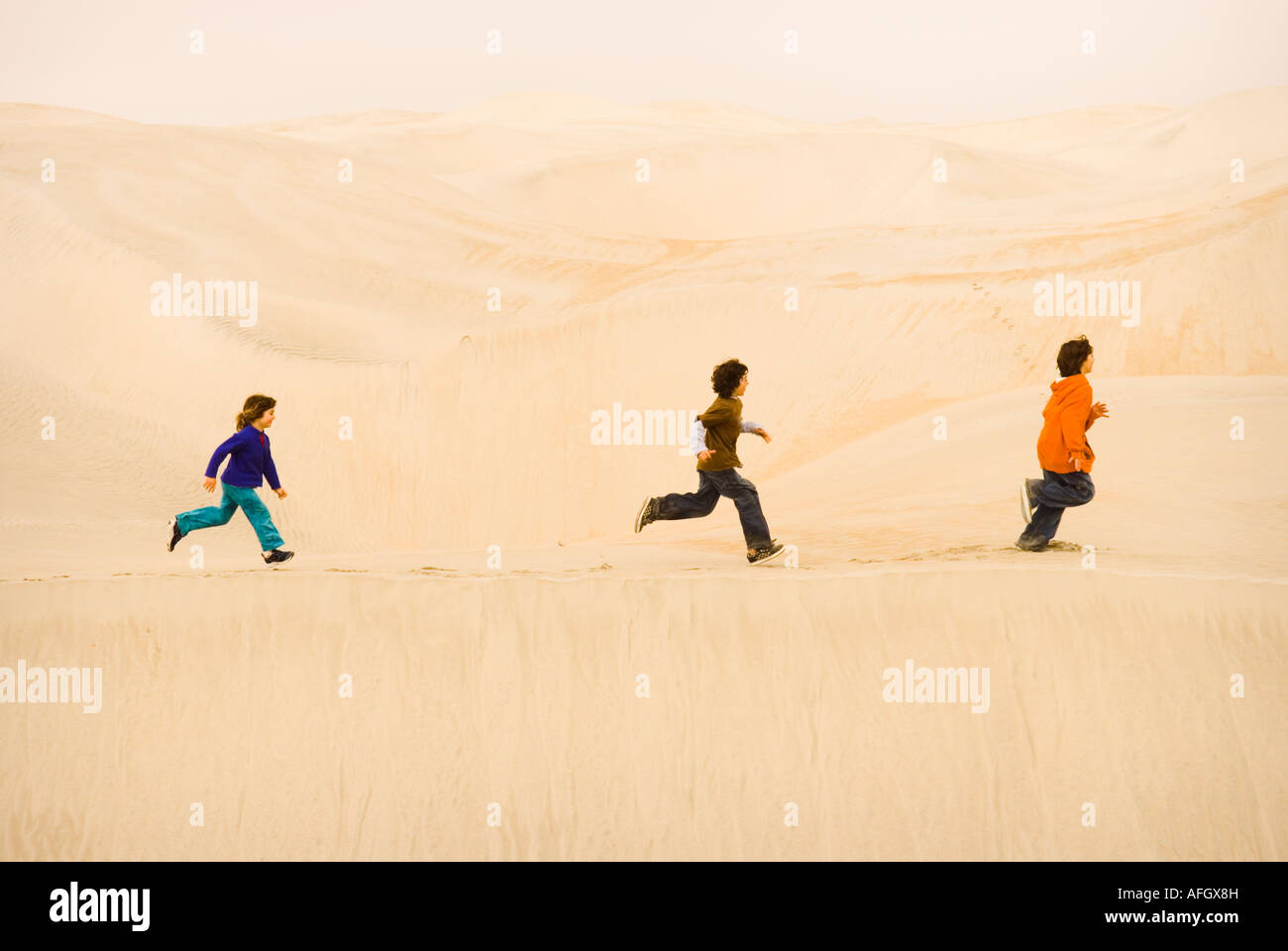 Kids Running on Sand Dune in Baja California Stock Photo - Alamy