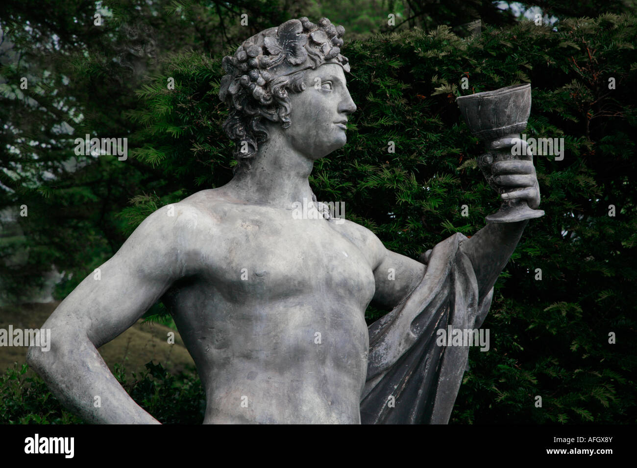 Lead garden sculpture of Bacchus drinking from a goblet Stock Photo - Alamy