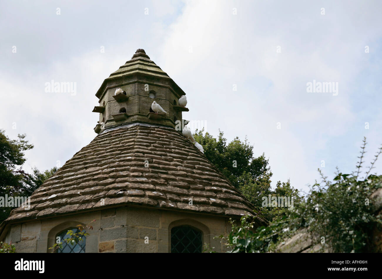 Old English stone dovecote with white doves Stock Photo - Alamy