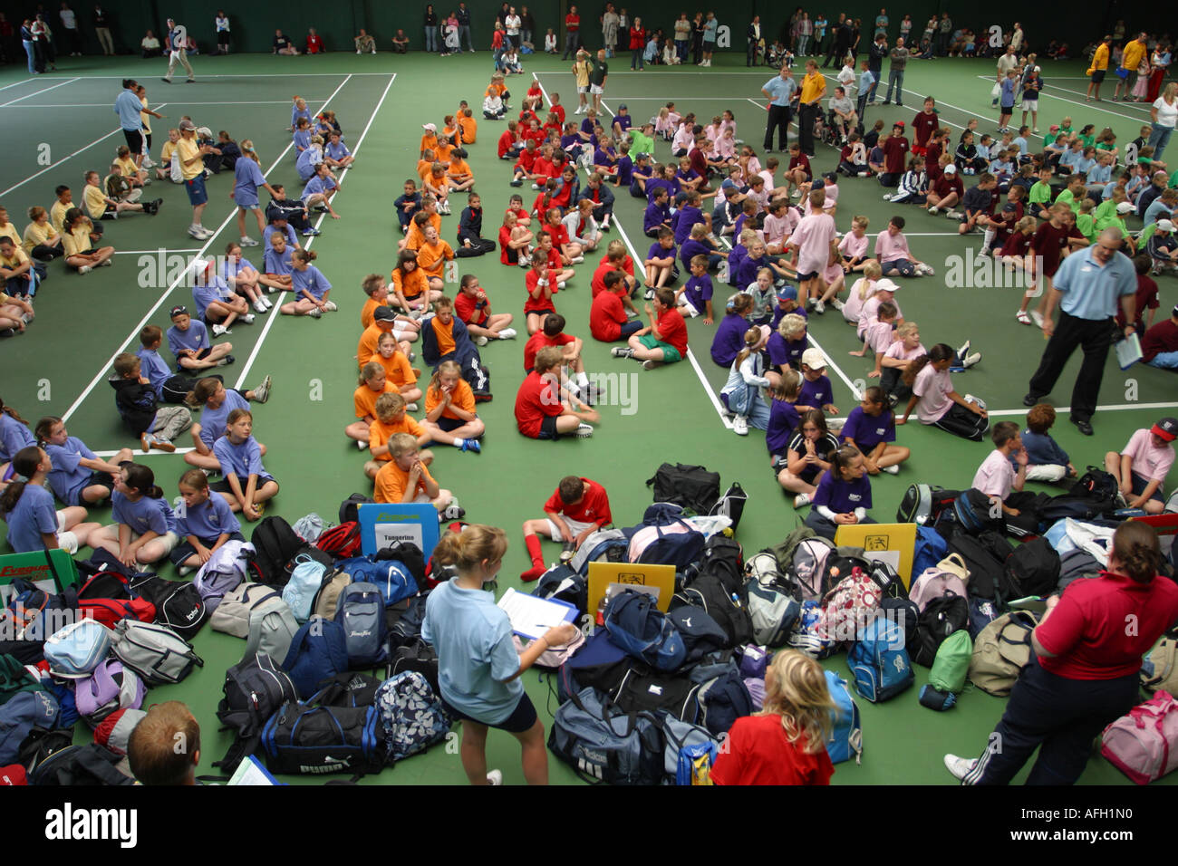 Young children waiting in sport team line queues at indoor sport venue ...