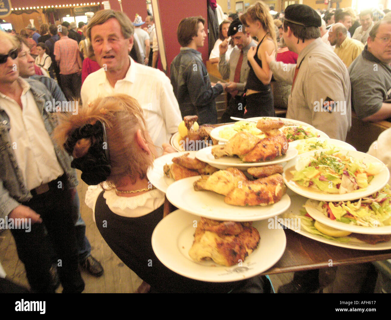Server waitress carry tray of roasted chicken or roasted meat around in ...