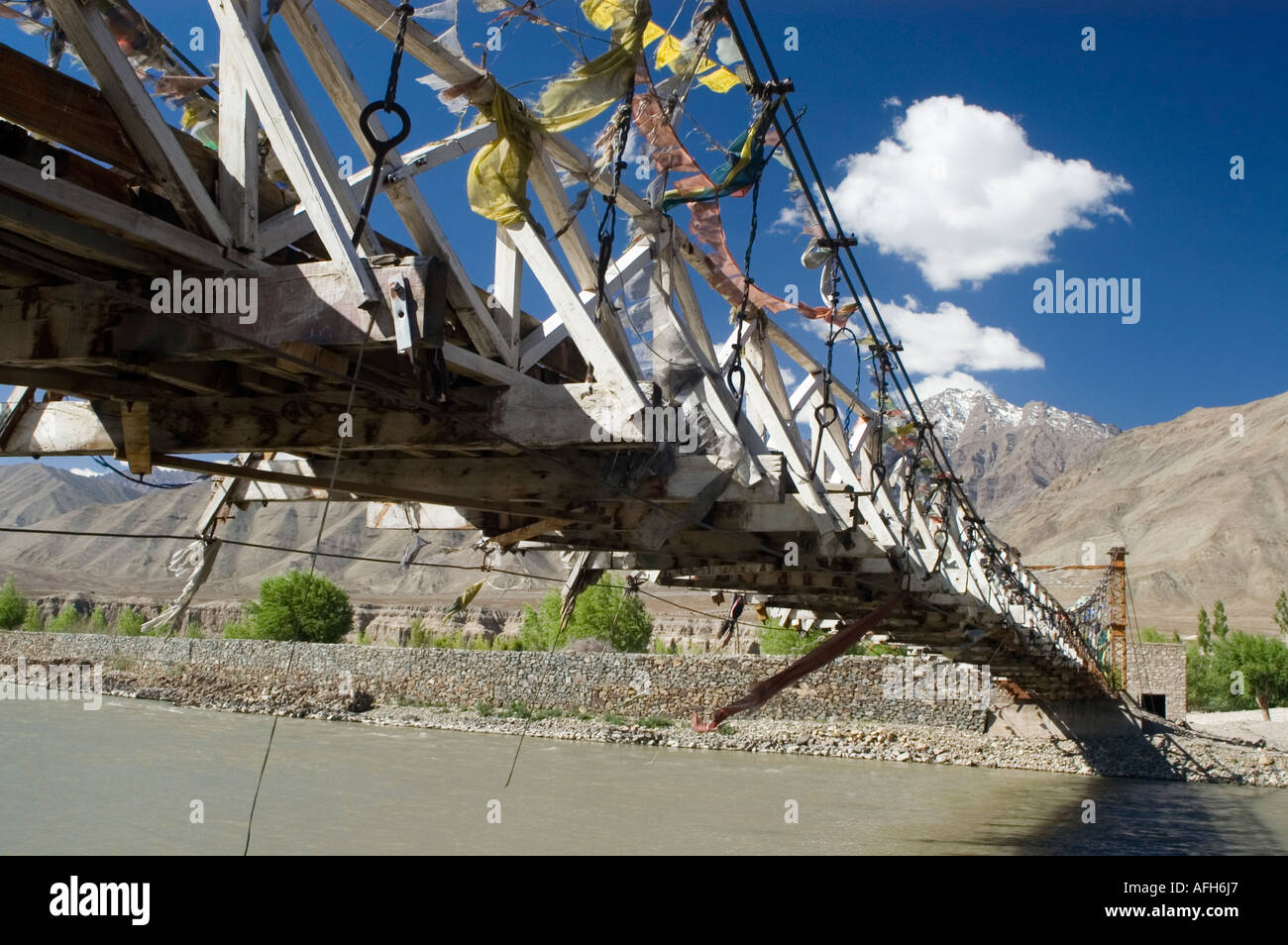 Swing bridge with prayer flags over the Indus river, Ladakh, Jammu and ...