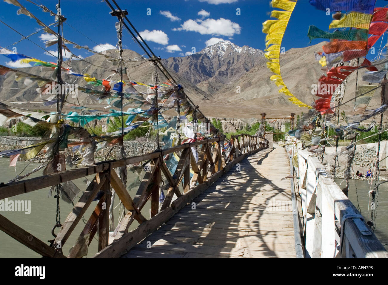 Swing bridge with prayer flags over the Indus river, Ladakh, Jammu and ...