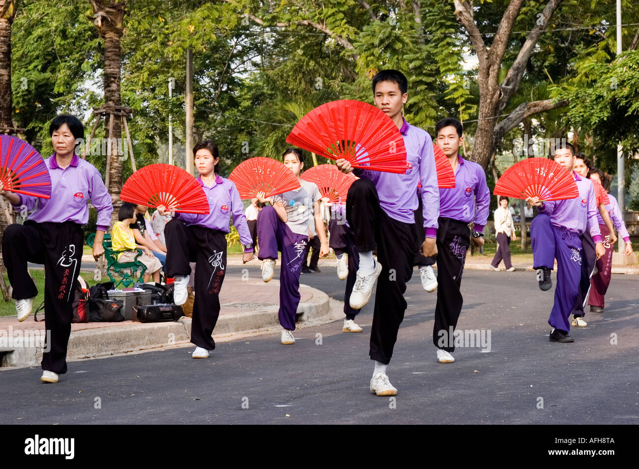 Tai Chi group of men and women with red fans in Lumpini Park, Silom ...
