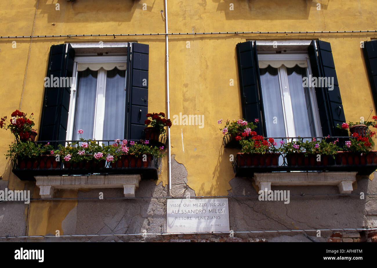 Windows shutters and flowerboxes in orange Stucco wall Venice Italy ...