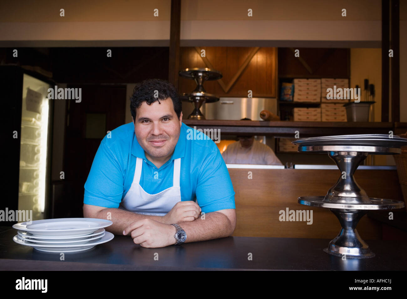 Portrait of chef behind restaurant counter Stock Photo - Alamy