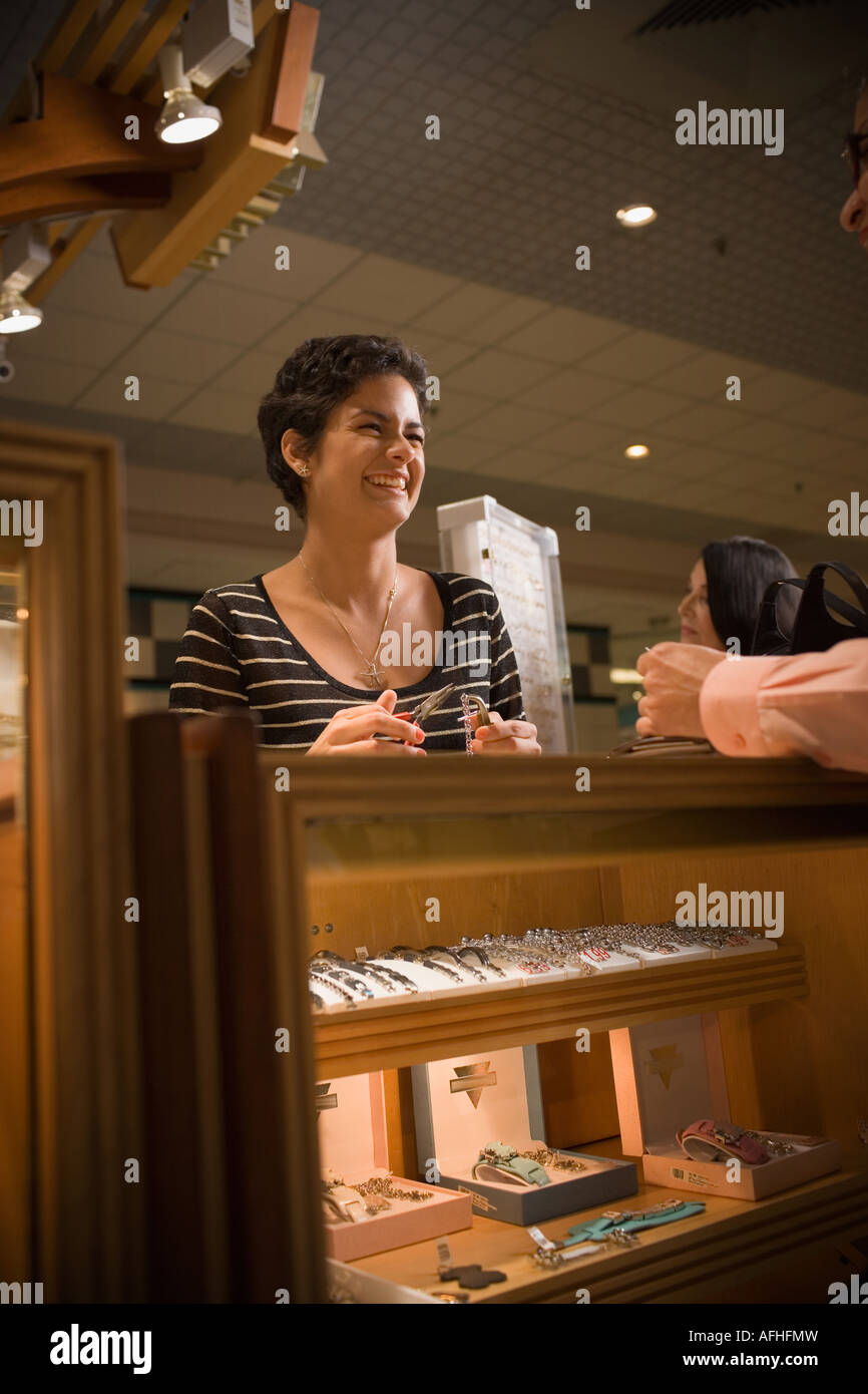 Young woman helping customer in jewelry store Stock Photo - Alamy
