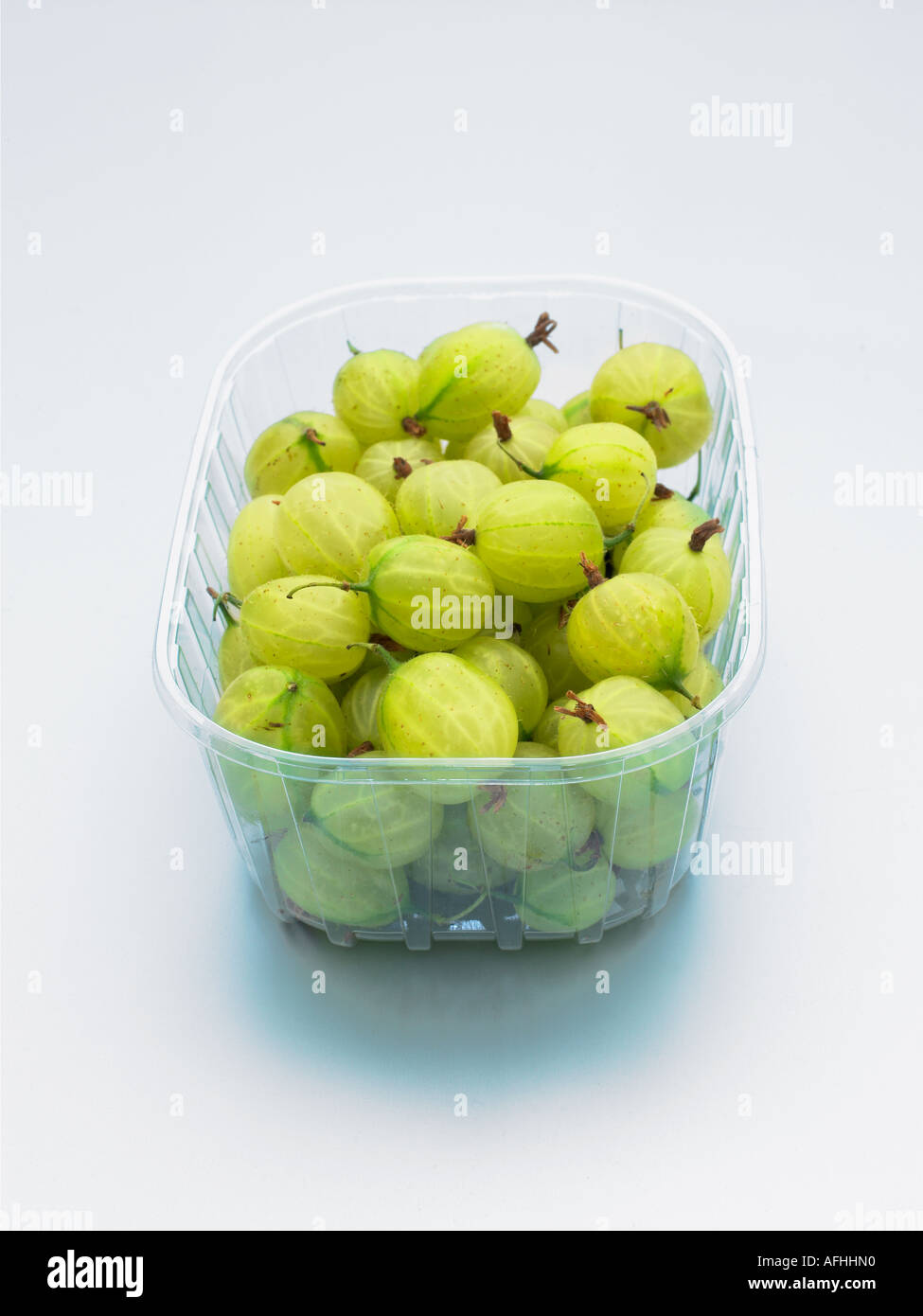 Punnet of gooseberries on white surface Stock Photo - Alamy