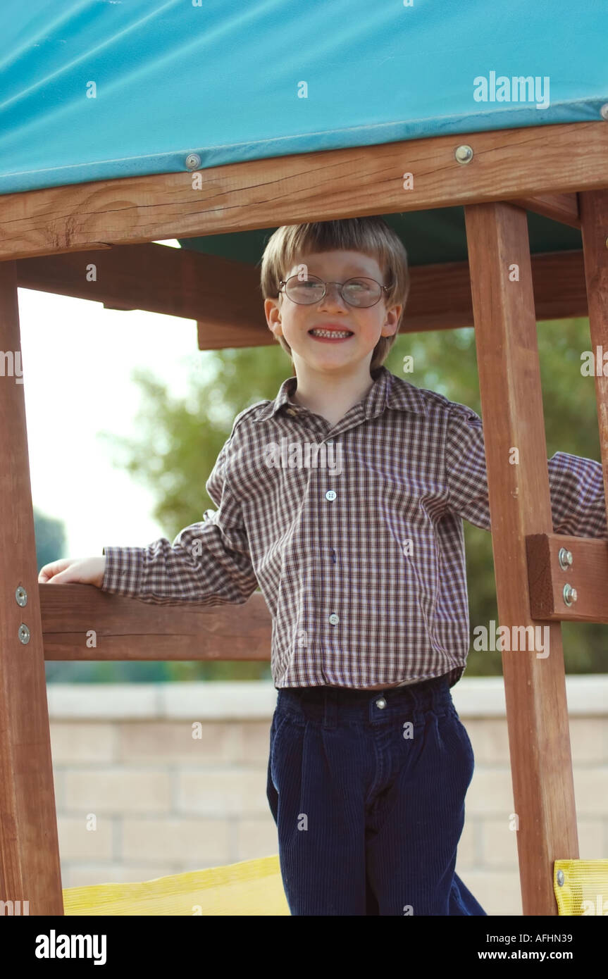 a young boy standing on a wooden playground set Stock Photo - Alamy
