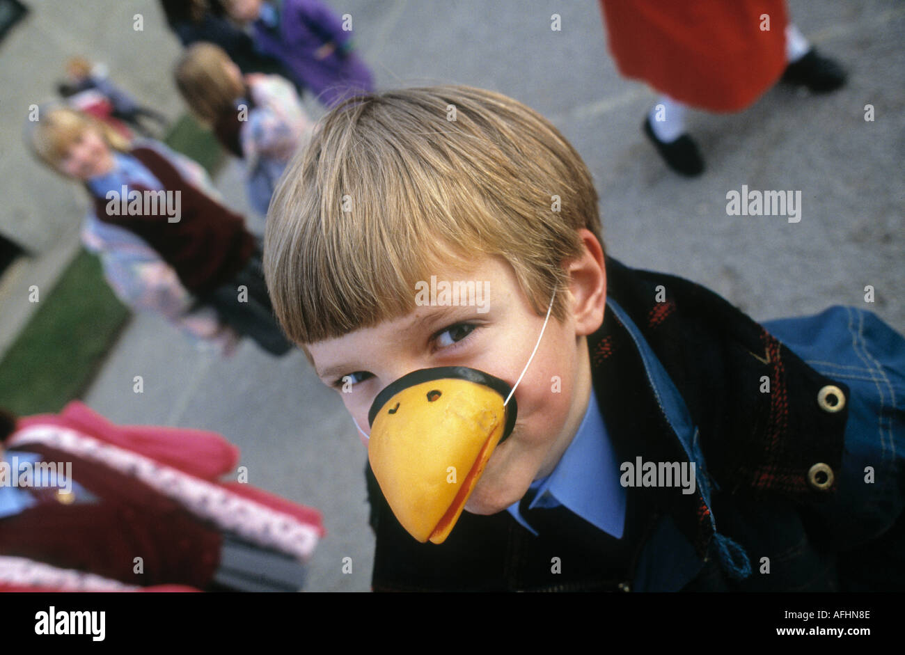 Playground scene with kid wearing a birds beak Stock Photo - Alamy
