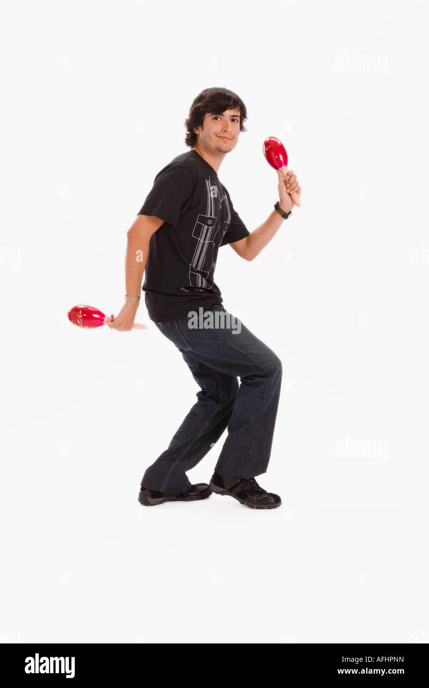 Studio portrait of young man dancing with maracas Stock Photo - Alamy