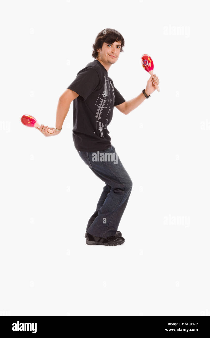 Studio portrait of young man dancing with maracas Stock Photo - Alamy
