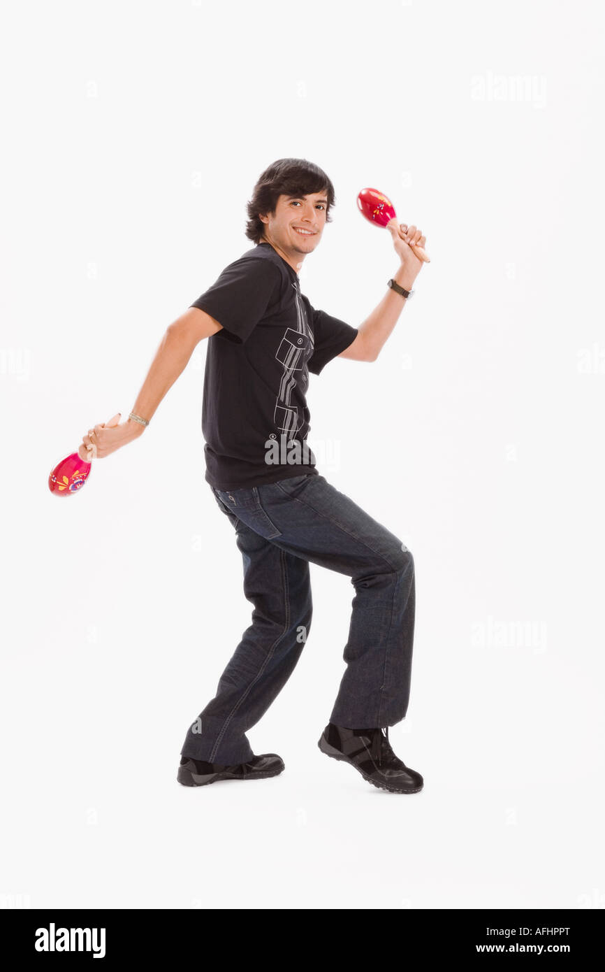 Studio portrait of young man dancing with maracas Stock Photo - Alamy