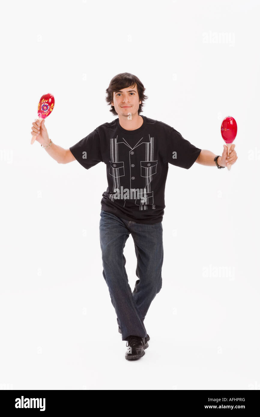 Studio portrait of young man dancing with maracas Stock Photo - Alamy