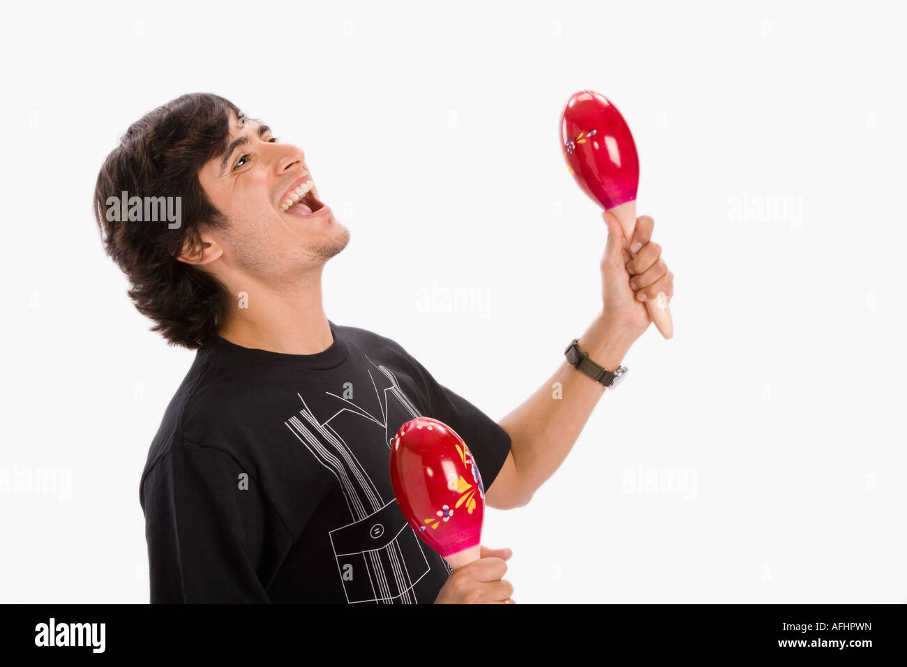 Studio portrait of young man dancing with maracas Stock Photo - Alamy