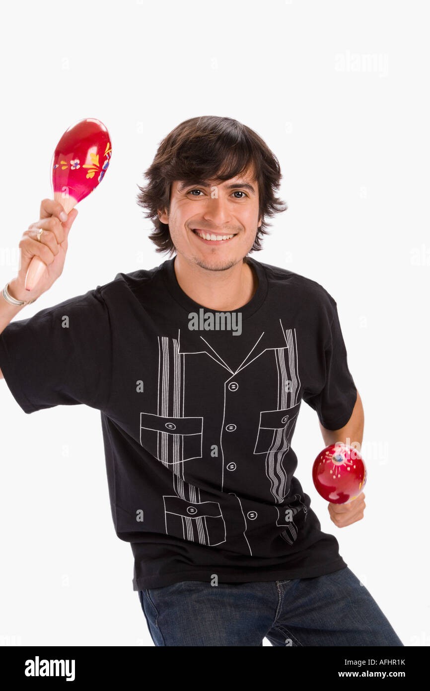 Studio portrait of young man dancing with maracas Stock Photo - Alamy