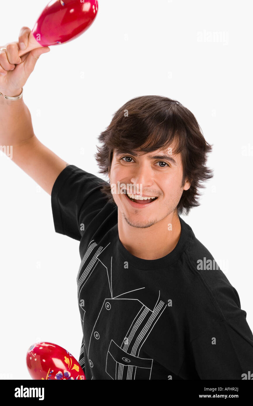 Studio portrait of young man dancing with maracas Stock Photo - Alamy