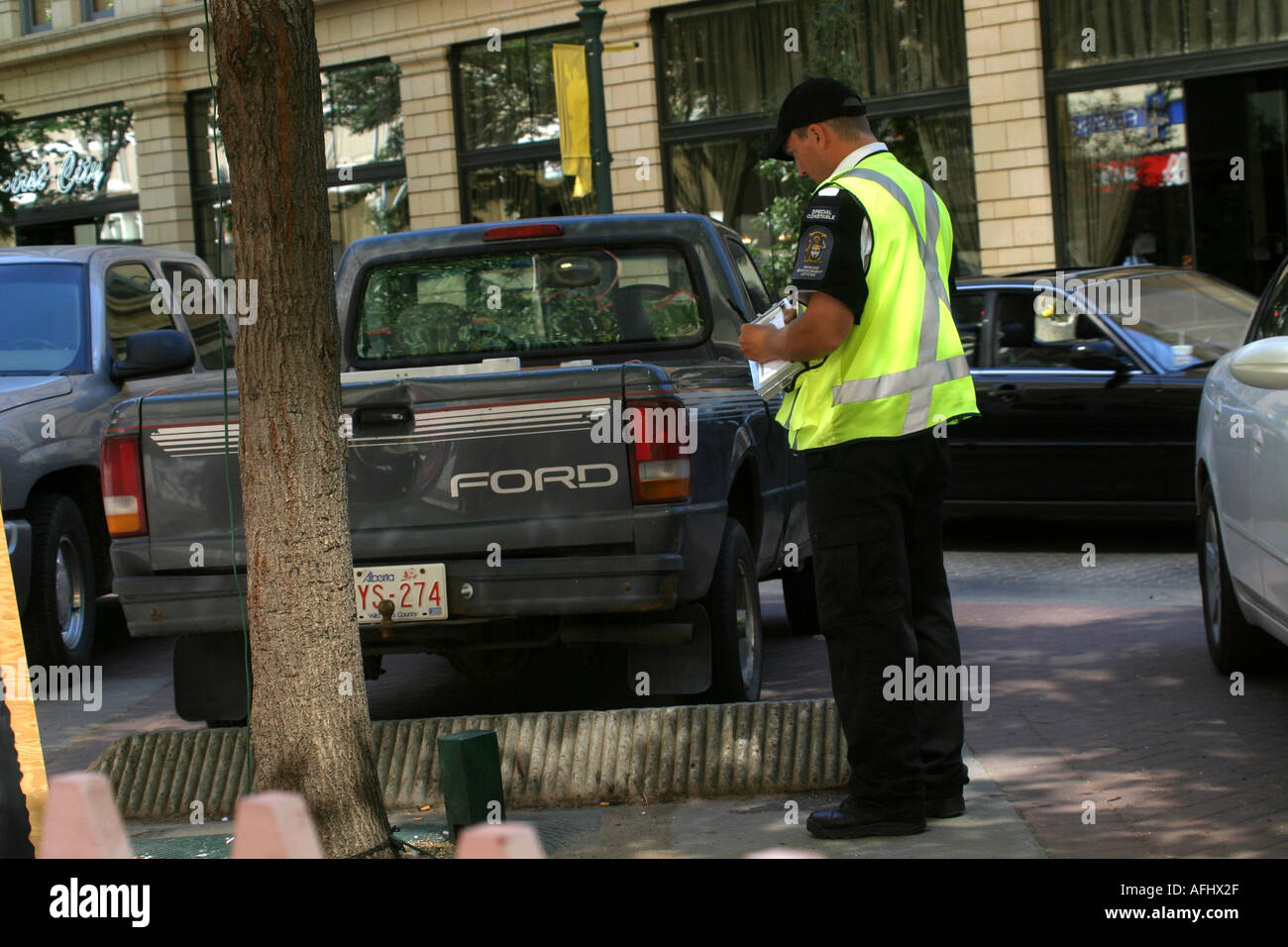 Policeman writing out a parking ticket Stock Photo - Alamy