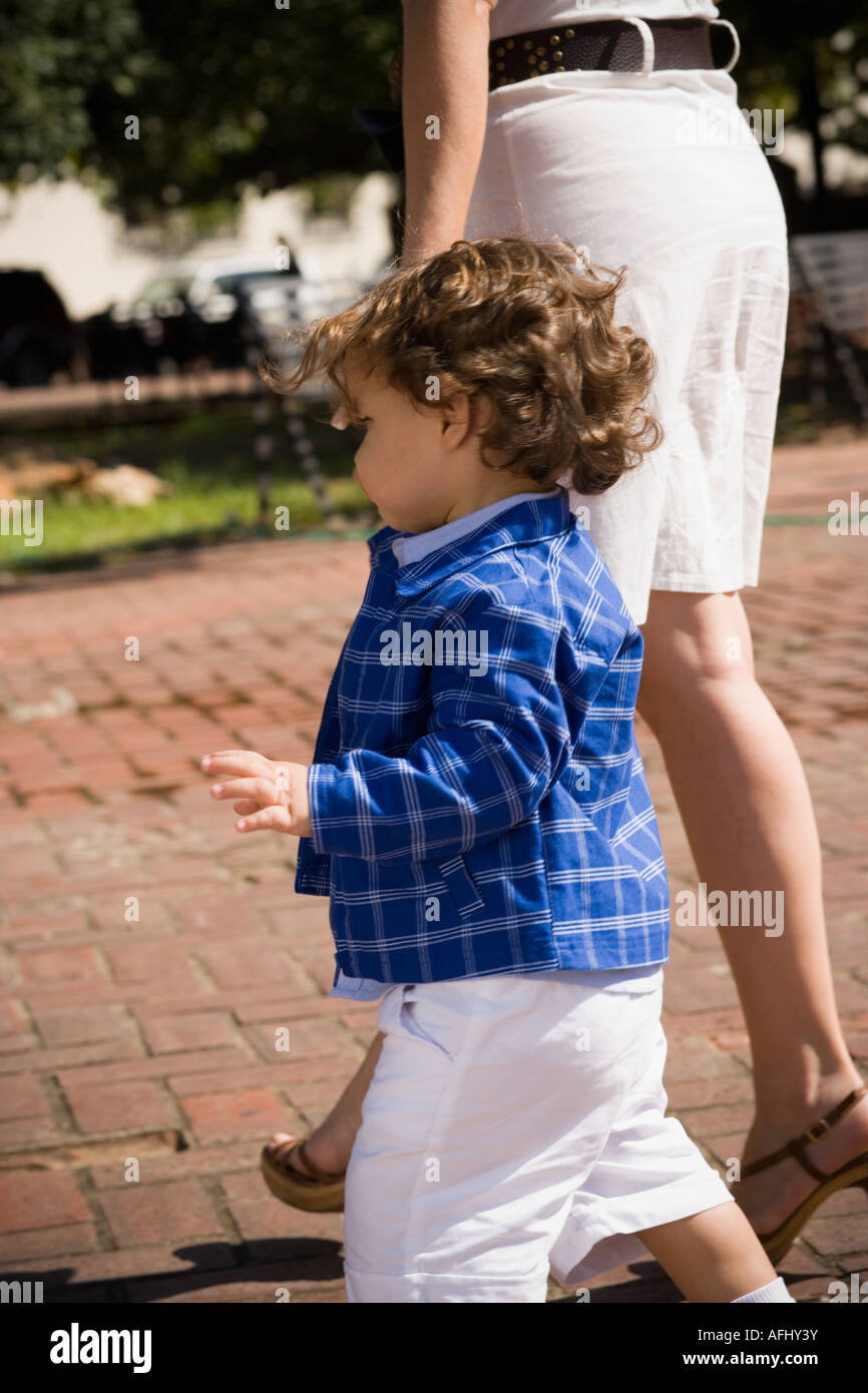 Side profile of a baby boy walking with his mother Stock Photo - Alamy