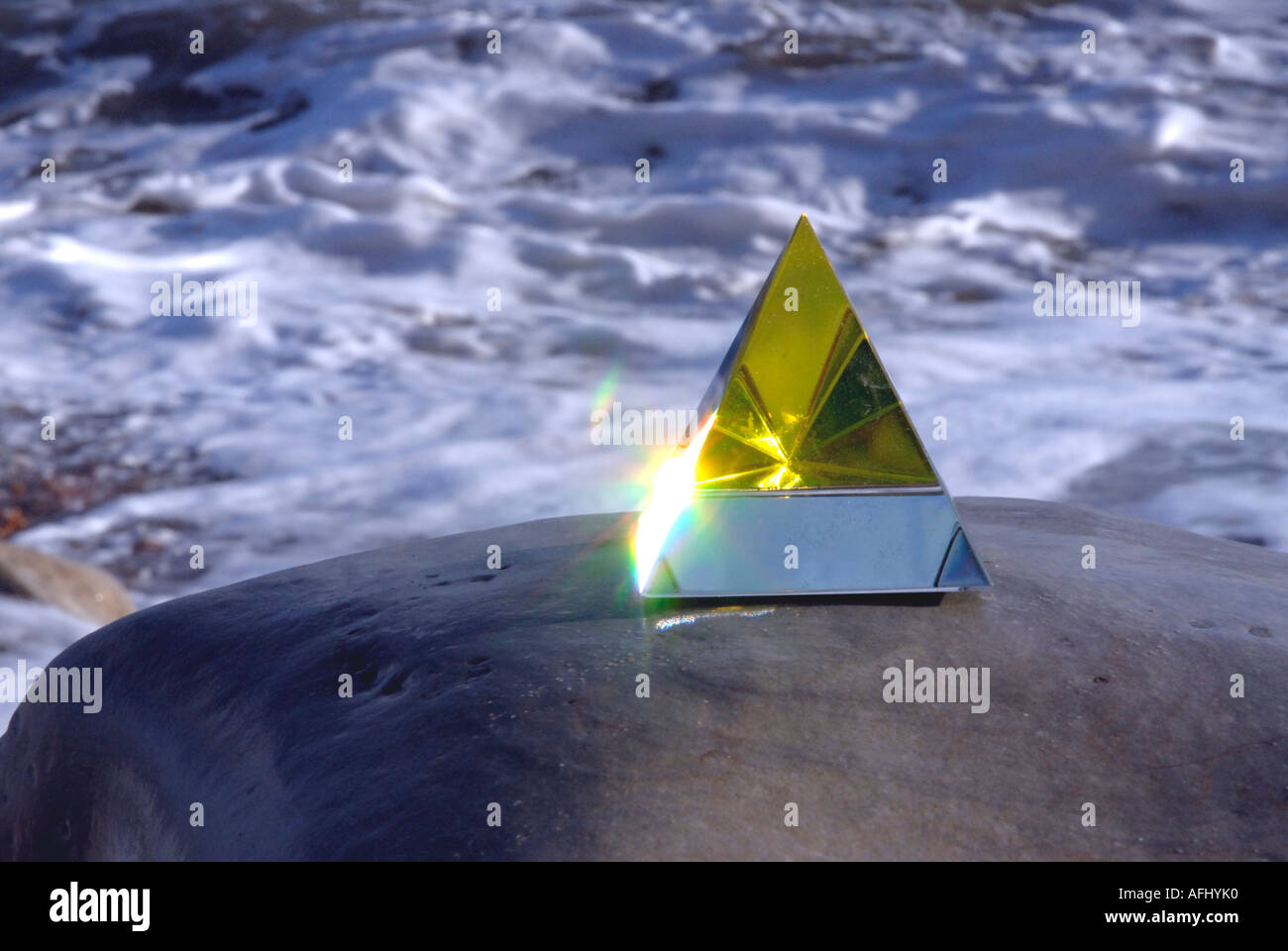 Glass pyramid prism light colour beach sand rock pebble sea seashore ...