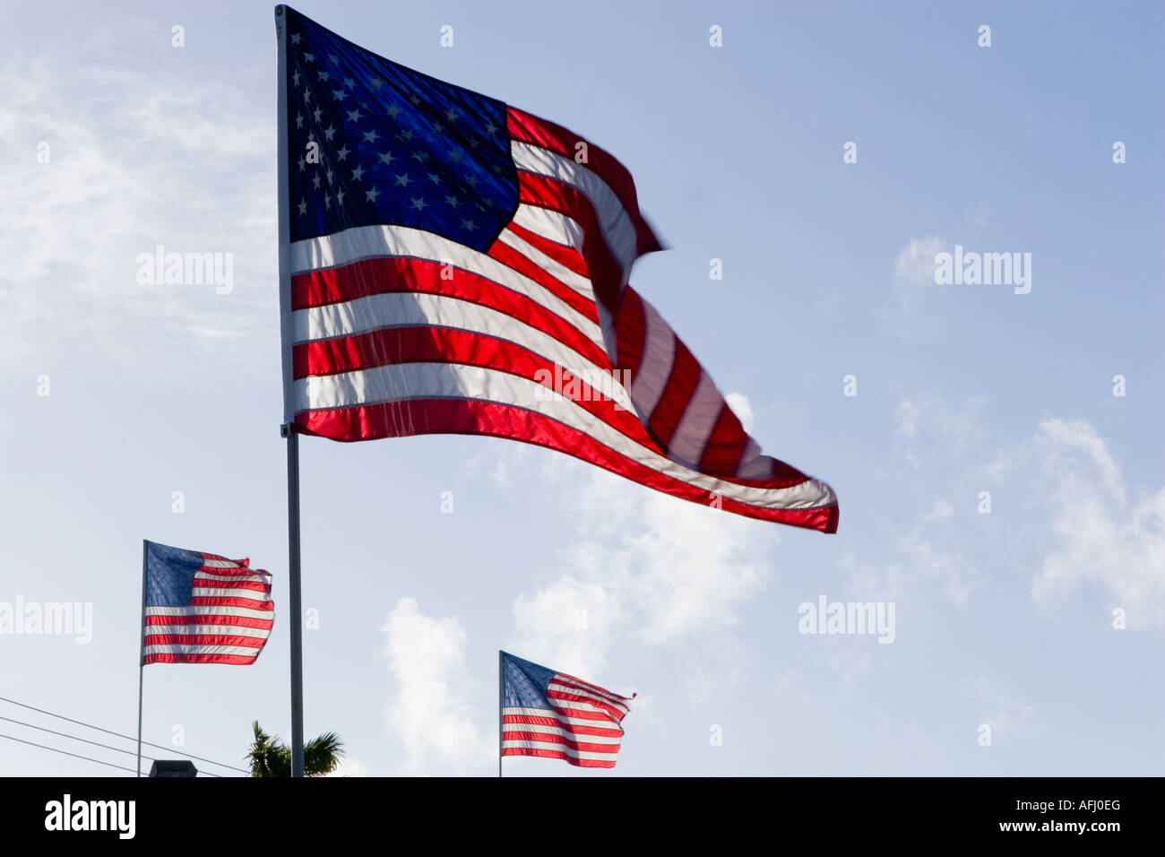 Low angle view of three American flags fluttering Stock Photo - Alamy