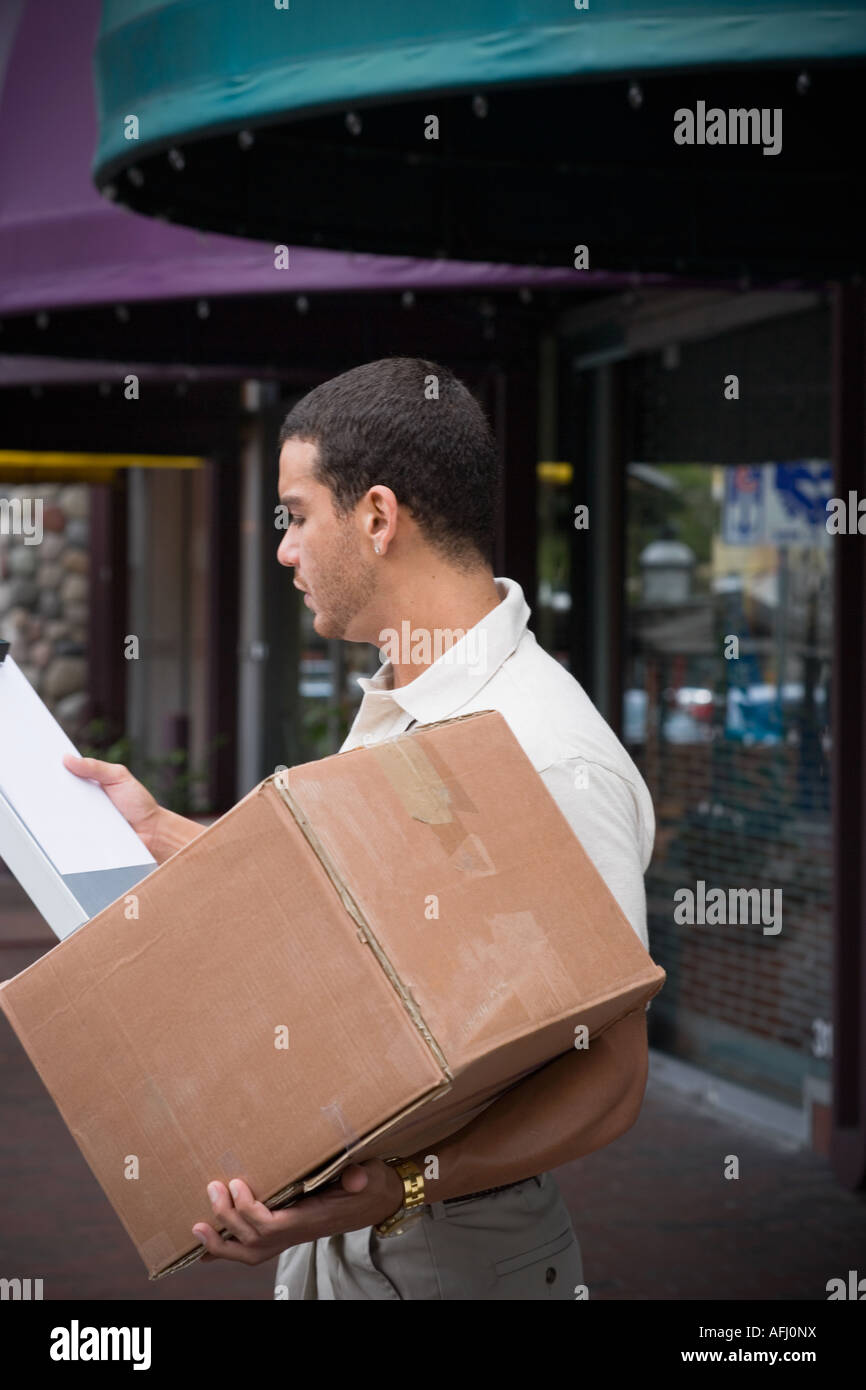 Delivery man carrying large box Stock Photo - Alamy