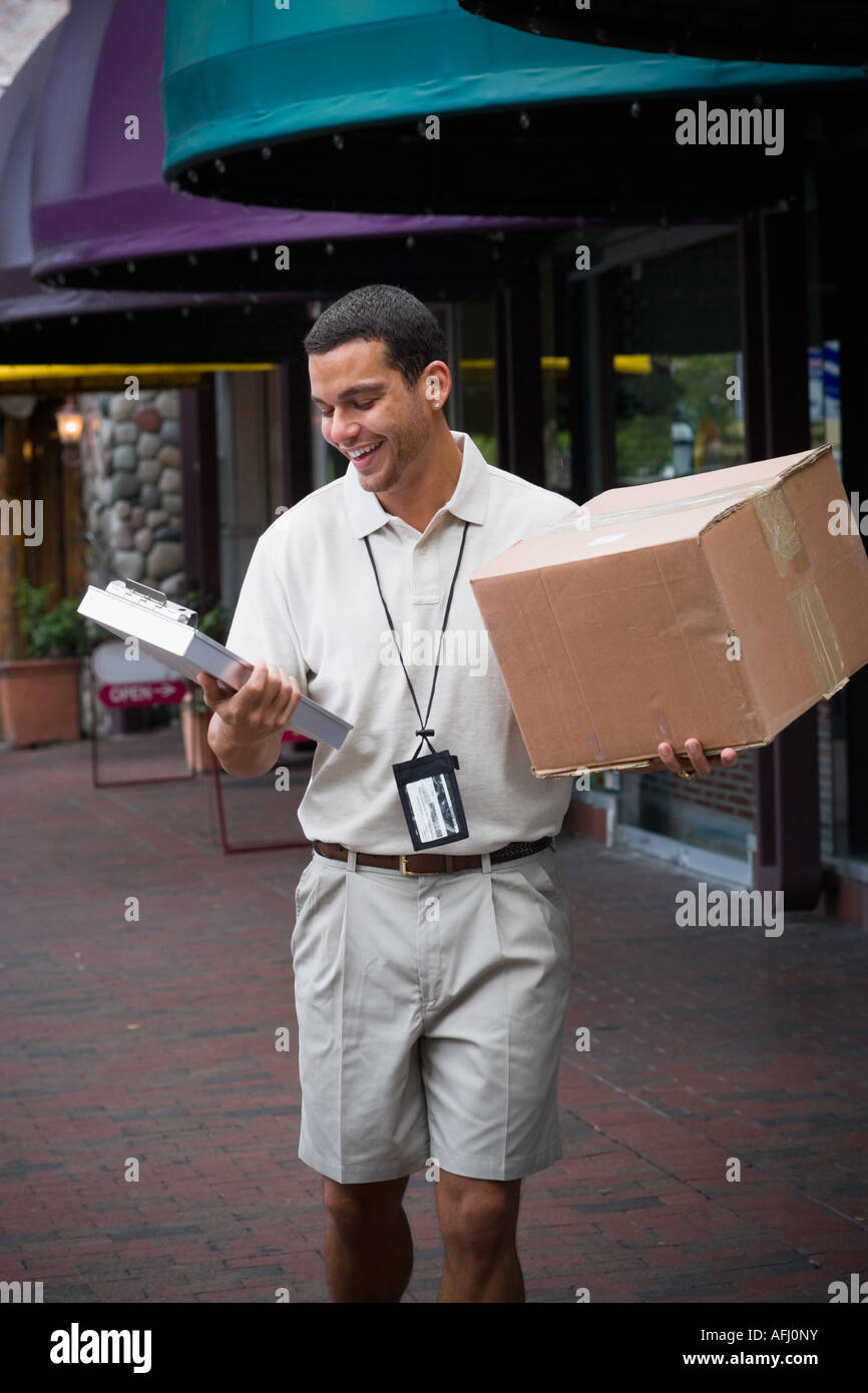 Delivery man carrying large box Stock Photo - Alamy