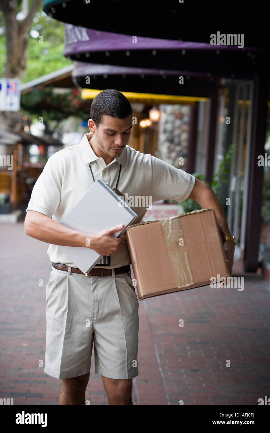 Delivery man carrying large box Stock Photo - Alamy