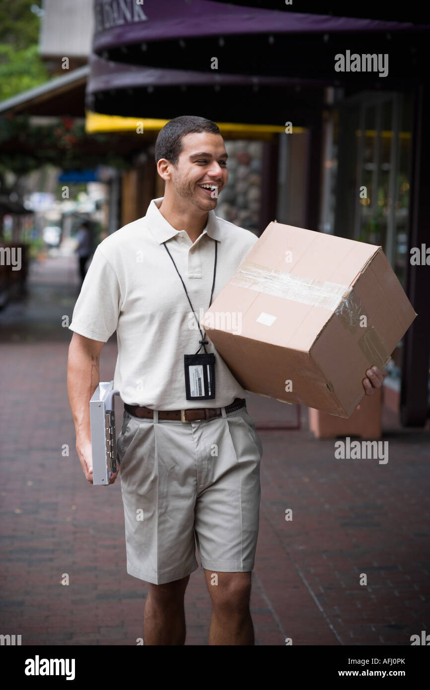 Delivery man carrying large box Stock Photo - Alamy