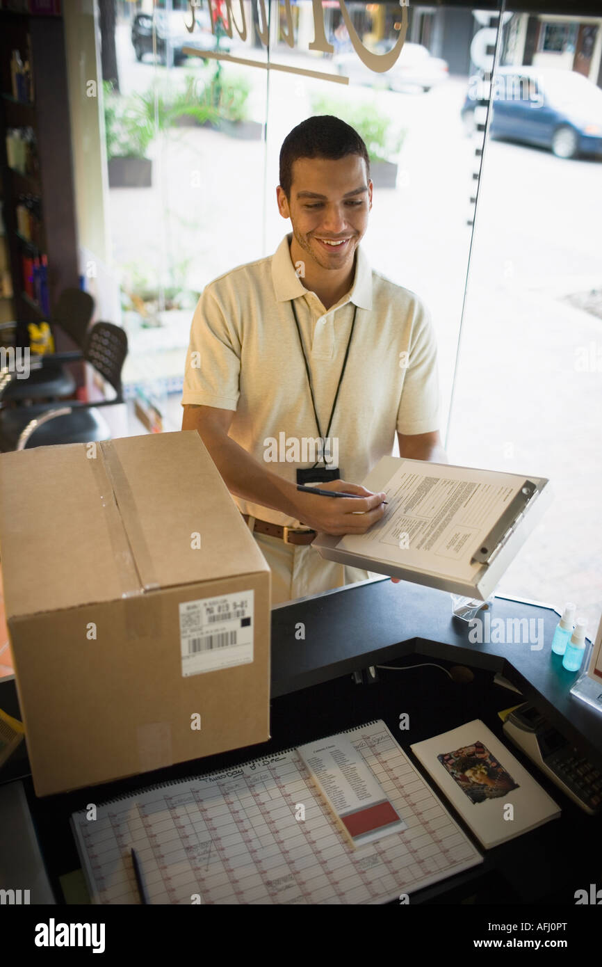 Delivery person making delivery to salon Stock Photo - Alamy