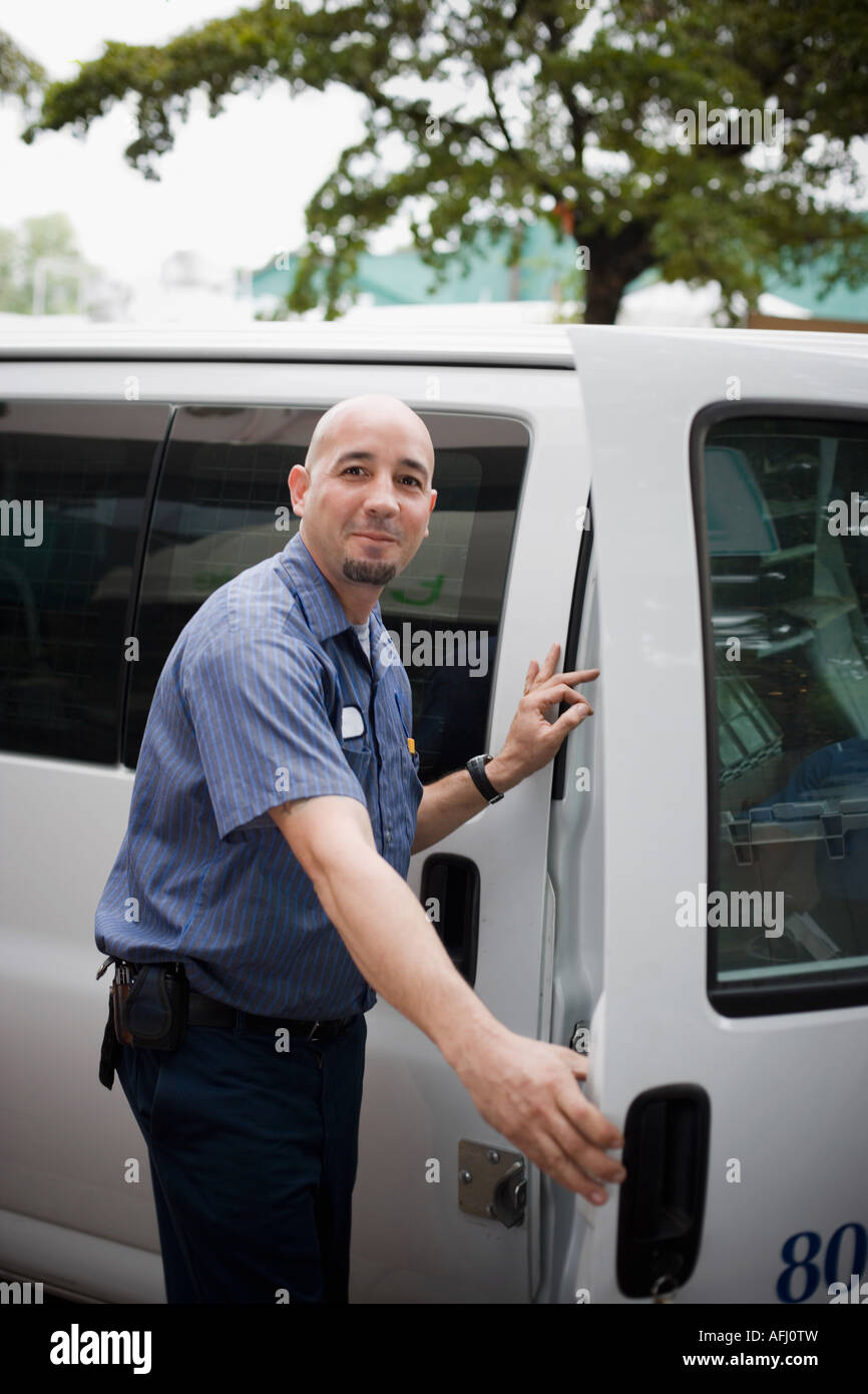 Blue collar worker getting in van Stock Photo - Alamy