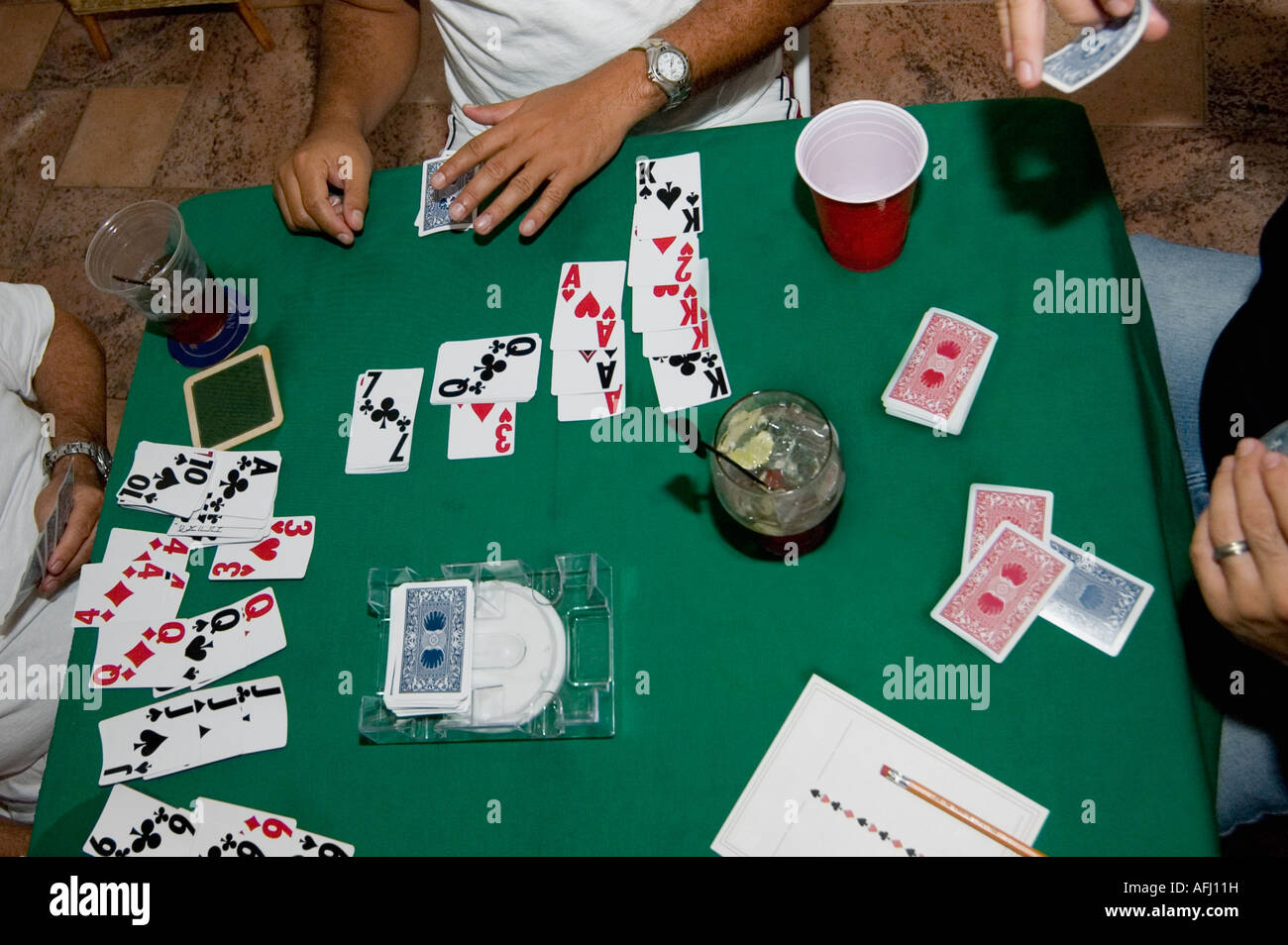 High angle view of three people playing cards Stock Photo - Alamy