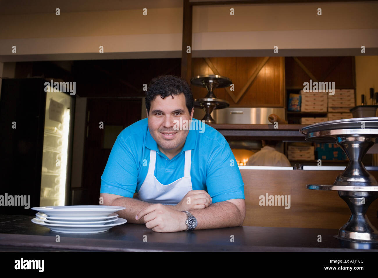Portrait of chef behind restaurant counter Stock Photo - Alamy