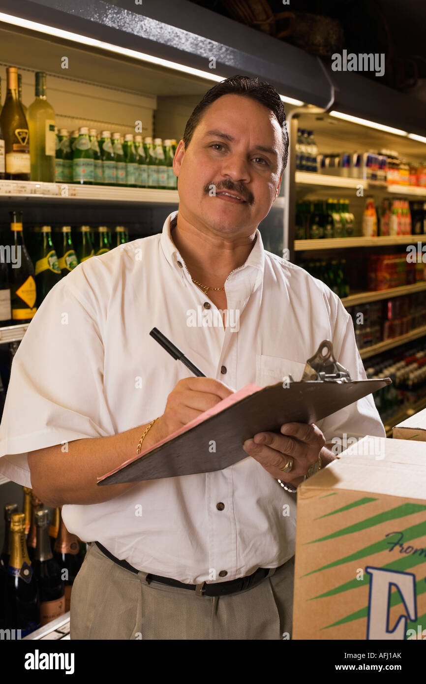 Small businessman taking inventory of groceries Stock Photo - Alamy