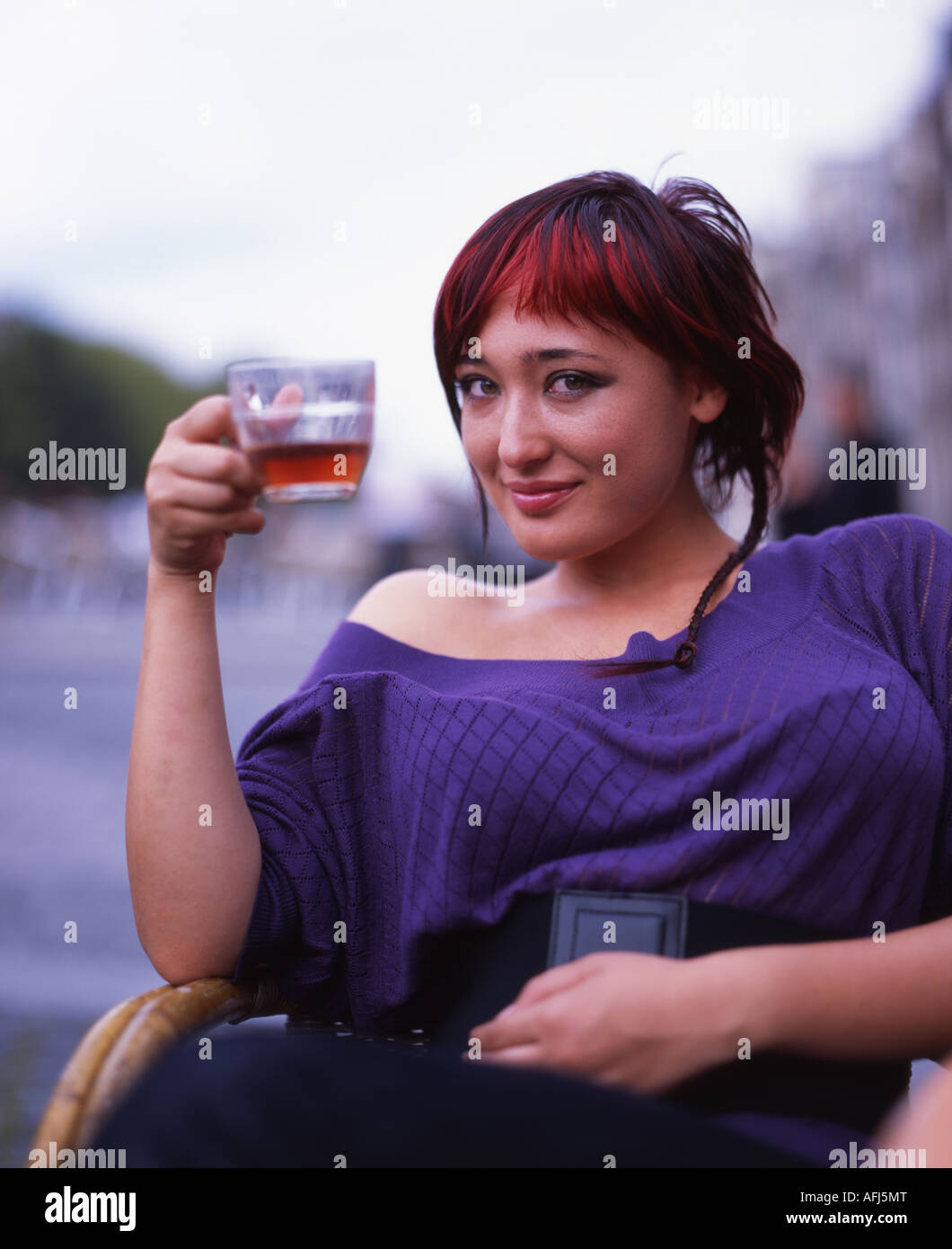 Beautiful Dutch girl sips tea in a cafe beside the canal in central ...
