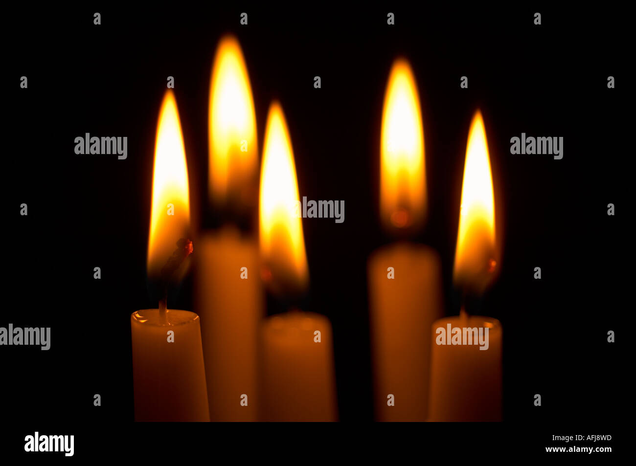 Five burning candles against a black background Stock Photo - Alamy