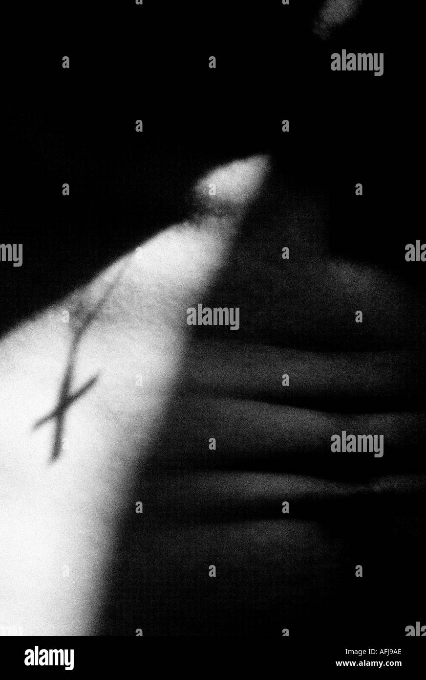 Shadow of cross on man's chest Stock Photo - Alamy