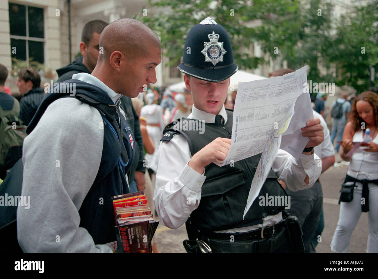 Police officer looking at road map helping passerby with street ...