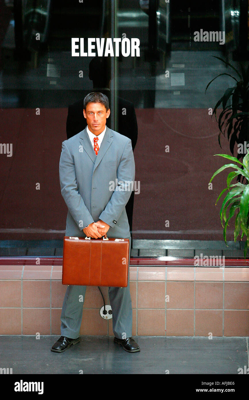BUSINESSMAN BY ELEVATOR SIGN Stock Photo - Alamy