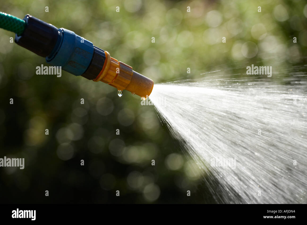 JET OF WATER SPRAYING FROM GARDEN HOSE PIPE IN SUMMER SUN Stock Photo ...
